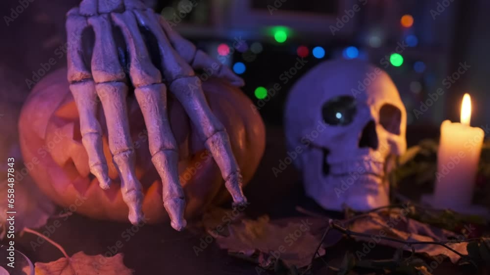Scary hands in a skeleton costume slowly stroke Jack-o'-lantern made of ...