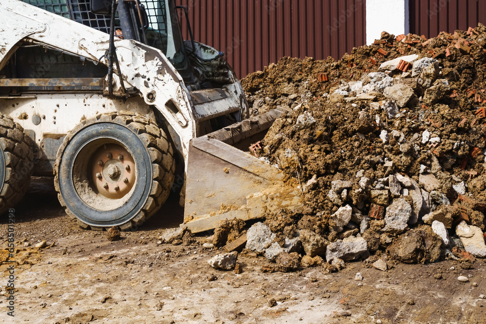 Wheel loader at landfill. Disposal of construction waste and concrete ...