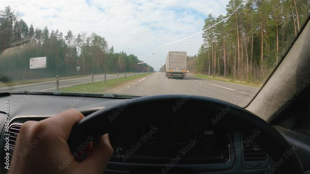 First-person view of driver's hand on steering wheel and dashboard ...