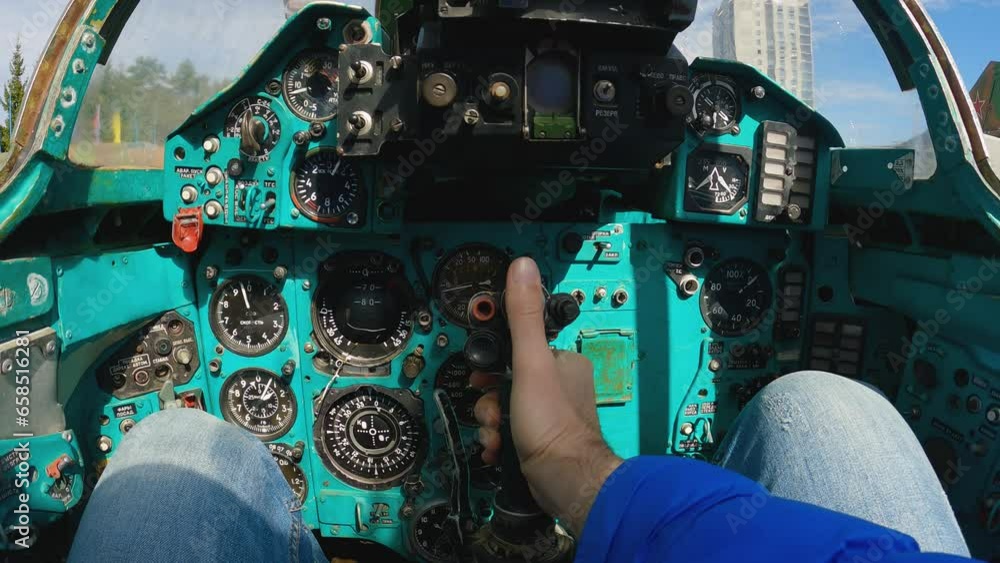 A first-person view of the cockpit of a Soviet Mig-23 fighter. A man's ...