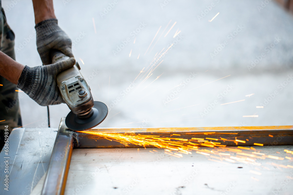 Grinding machine at work. Sparks fly from under the grinders, men's ...