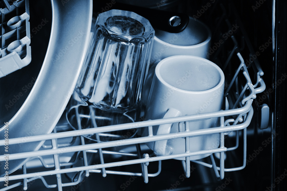 Inside dishwasher view. Washing dishes background. Full shelf with load ...