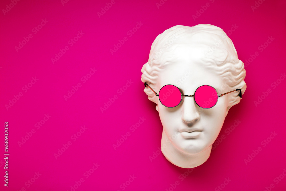 Quirky plaster statue of Aphrodite's head with round pink goggles ...