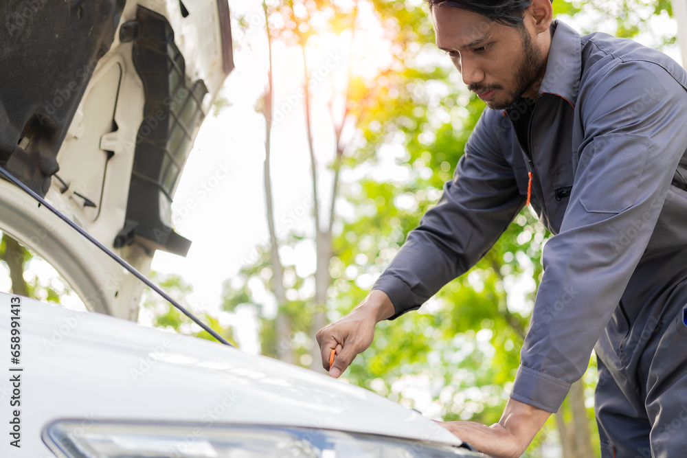 Auto mechanic inspects car by inspecting and writing checklist on ...