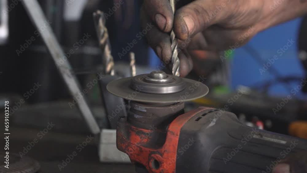 A master sharpens a drill using an emery disc. Sharpening a drill in a ...
