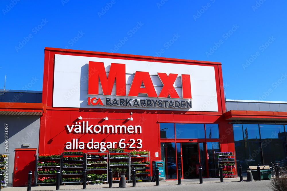 Entrance and exit of a grocery store. Ica Maxi sign on a large wall ...