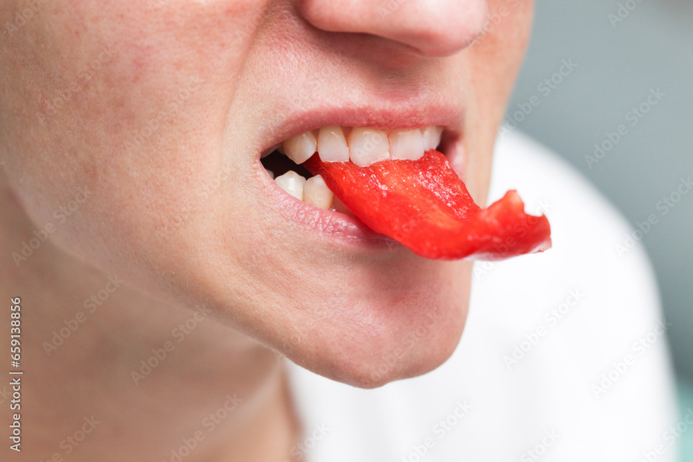 Eating red bell pepper. Girl holding vegetable in teeth. Woman eating ...