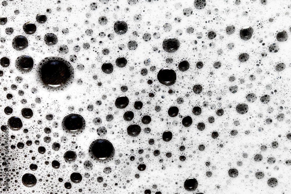 Soap bubbles texture. Black teflon frying pan cleaning. White suds ...