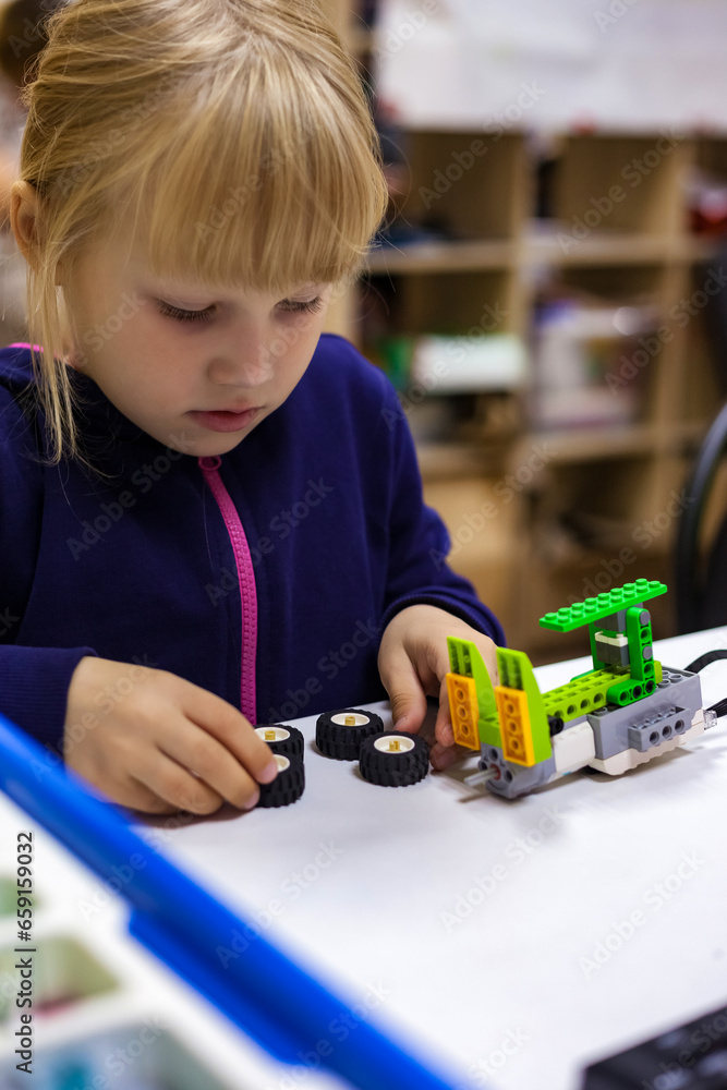 Kid girl 5 year old using constructor blocks and PC, technology ...