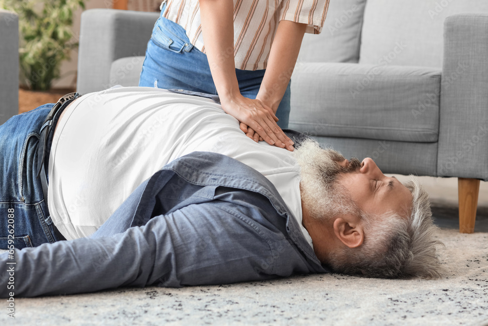 Woman doing CPR on her unconscious father at home Stock Photo | Adobe Stock