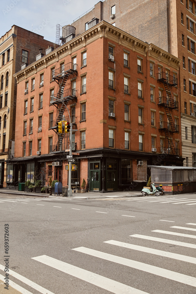 red brick building with storefront and fire escape stairs on crossroad ...