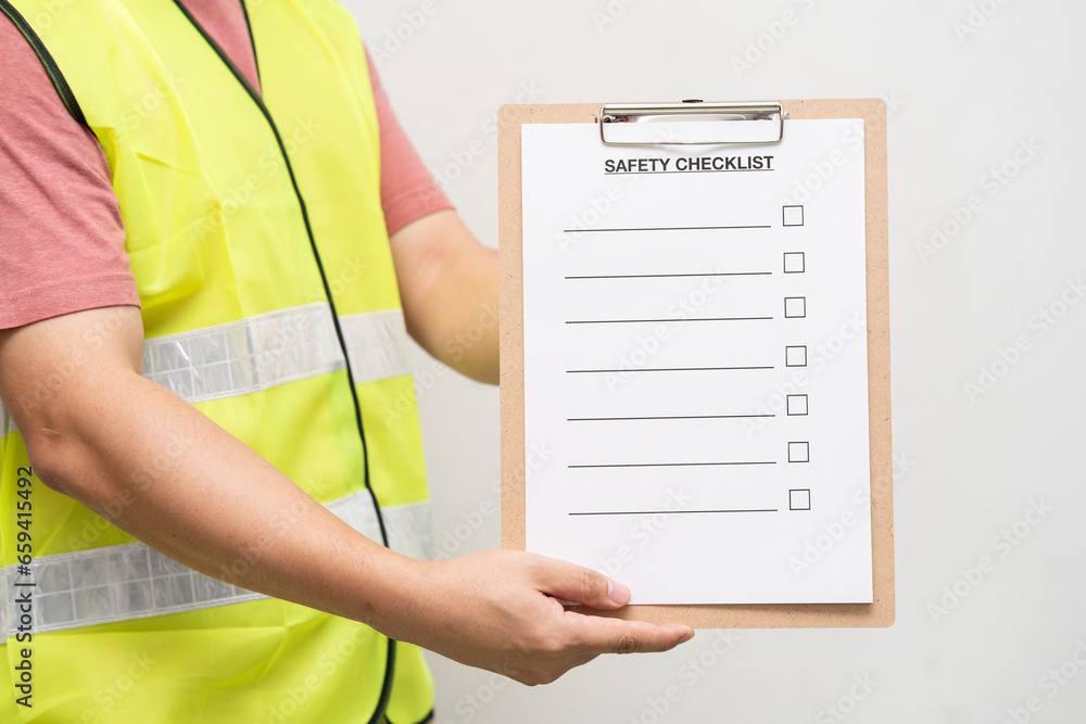 Staff holding blank checking on safety checklist form. Hand of staff is ...
