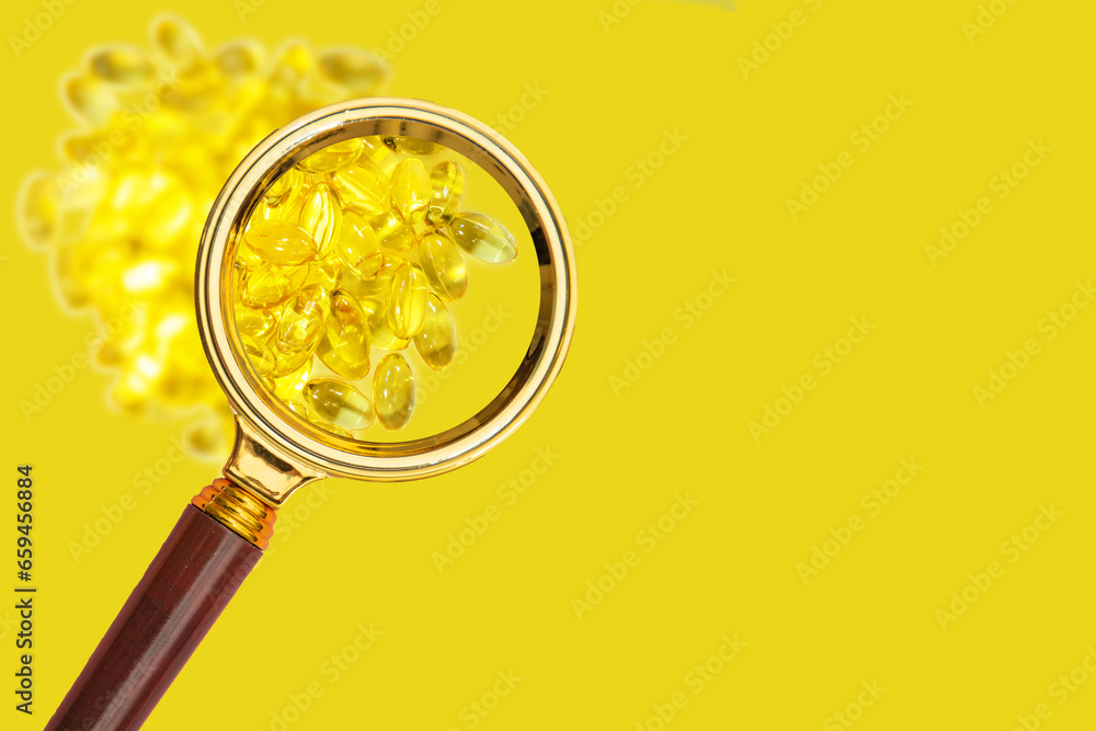 Cod liver vitamin E capsules seen through a magnifying glass. Blurred ...