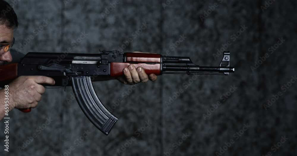 Side view of person shooting an AK-47 Rifle in high-speed 800 fps. Slow-motion of man aiming and ...