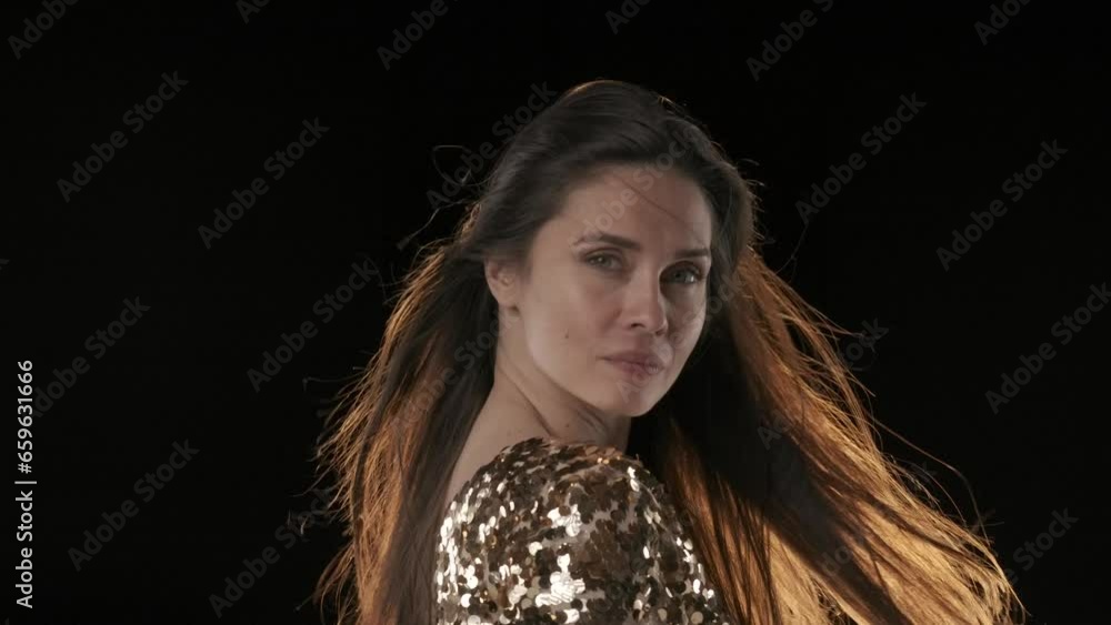 On a black background, middle-aged woman with dark hair. She is ...
