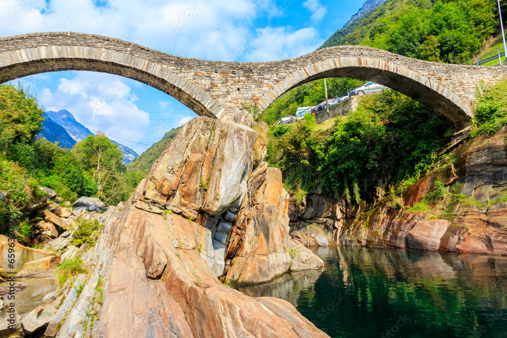 Ancient double arch stone Roman bridge (Ponte dei Salti) over the clear ...