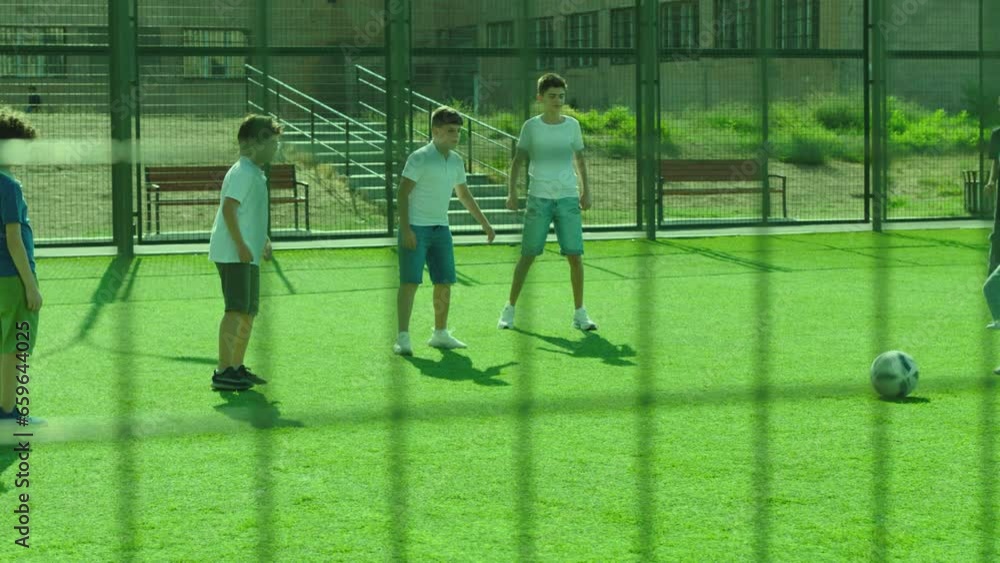 Group of boys playing football on sport playground in sunny day . Many ...