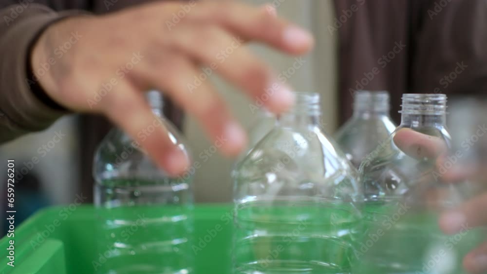 Close-up shot hand collecting and separating recycling plastic bottles ...