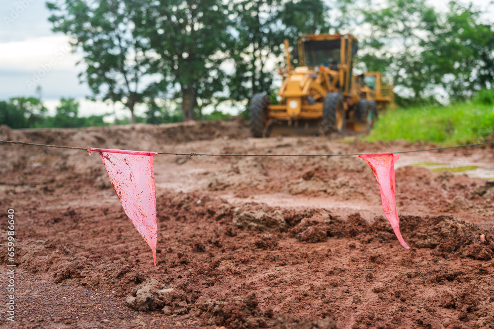 Red flag line to barricade the excavation working site with wet soil ...