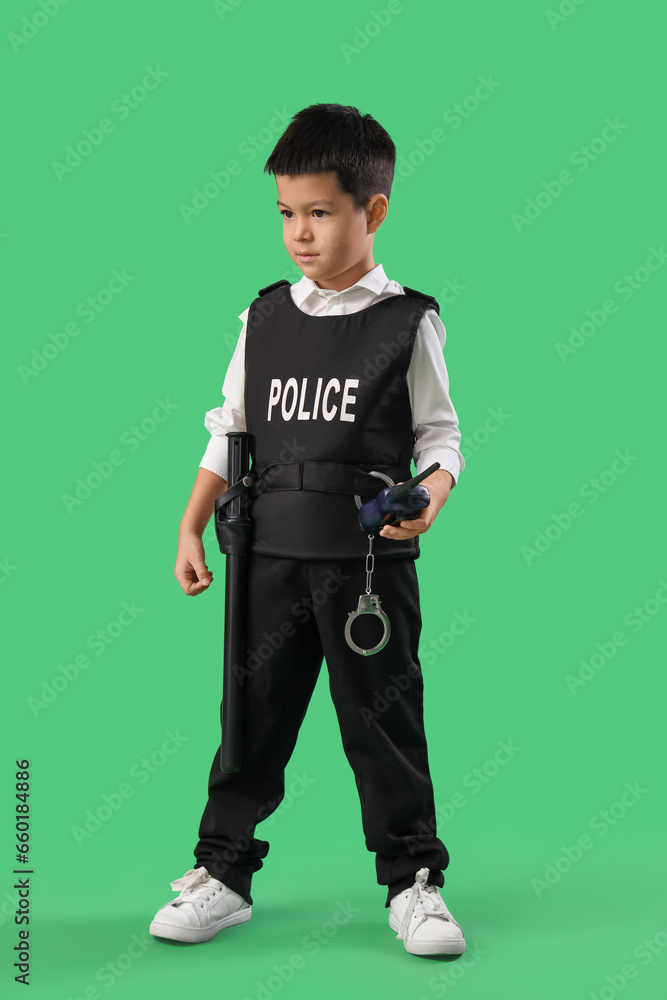 Cute little police officer with radio transmitter on green background ...