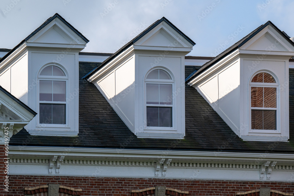 Three peaked dormer-style windows on a hip roof covered with black ...