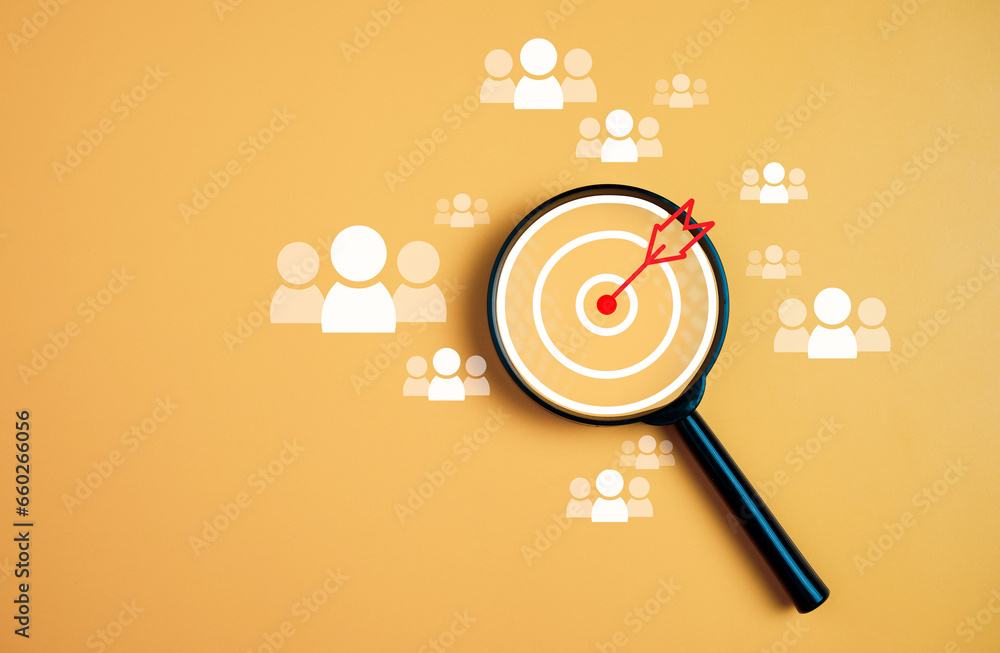 Customer group icons in a magnifying glass placed on a yellow ...