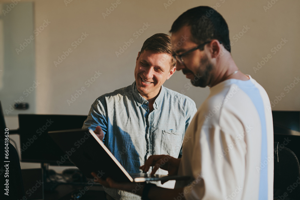 Portrait of two professional male programmers working on computer in ...