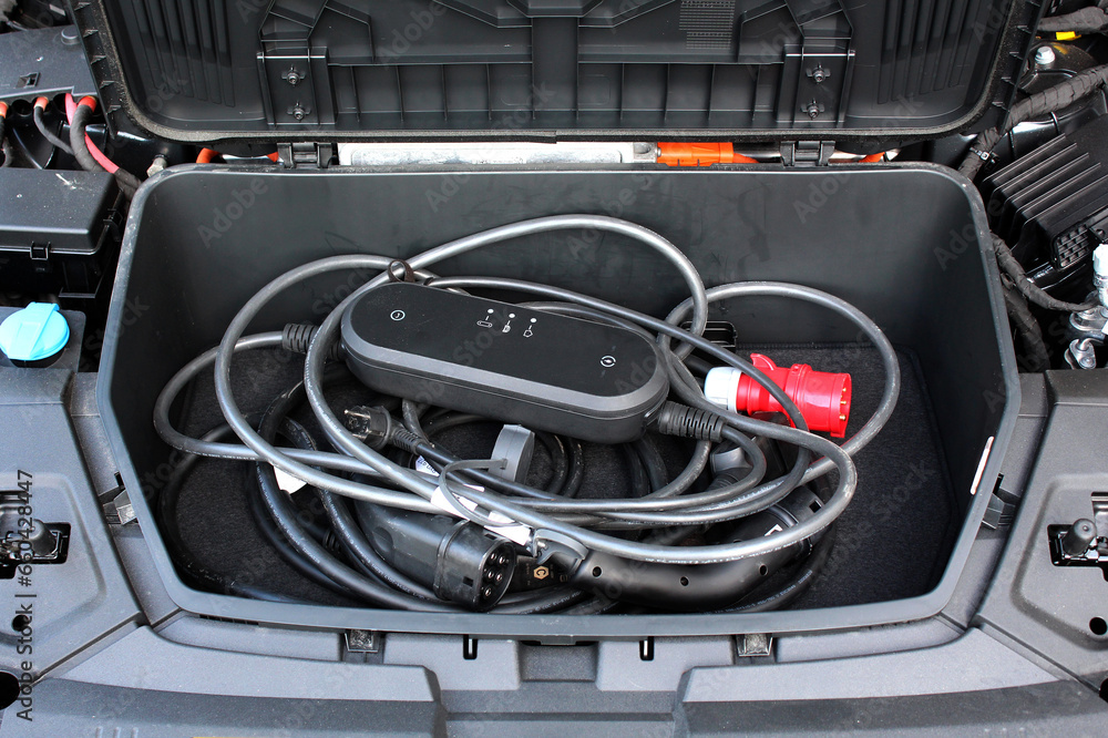 Electric vehicle charging cable in the hood of a car. Electric Vehicle ...