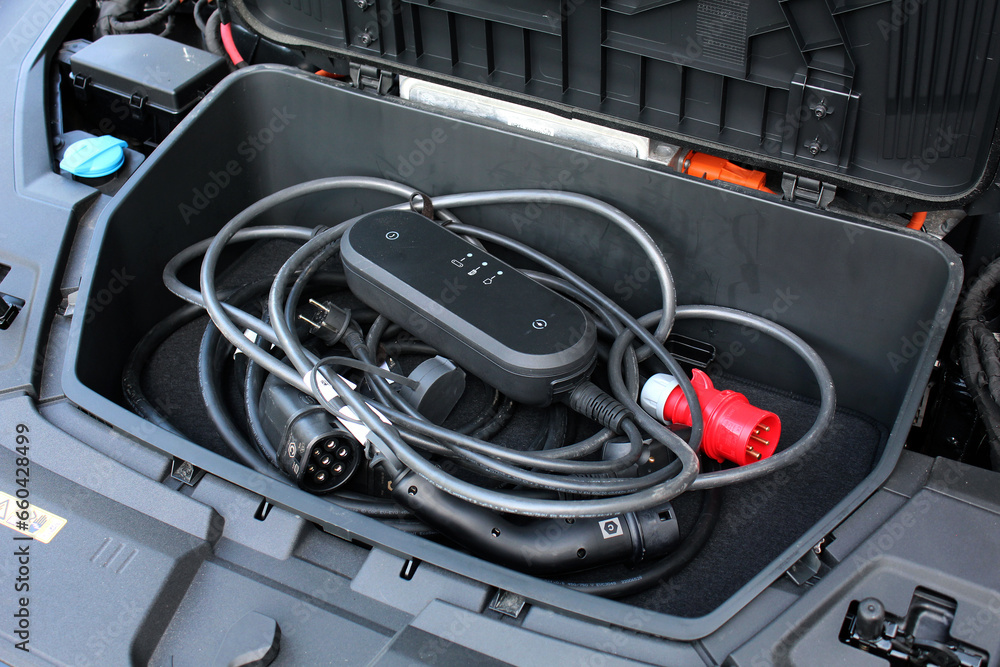 Electric vehicle charging cable in the hood of a car. Electric Vehicle ...