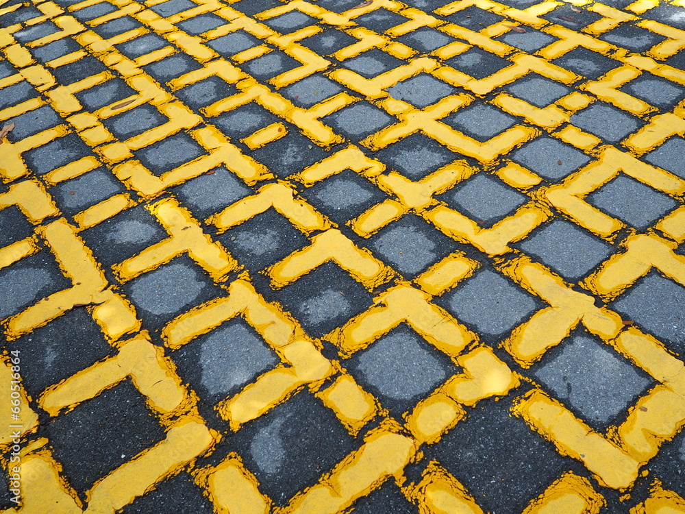 Traffic line wet from rain. Solid yellow lines running diagonally ...