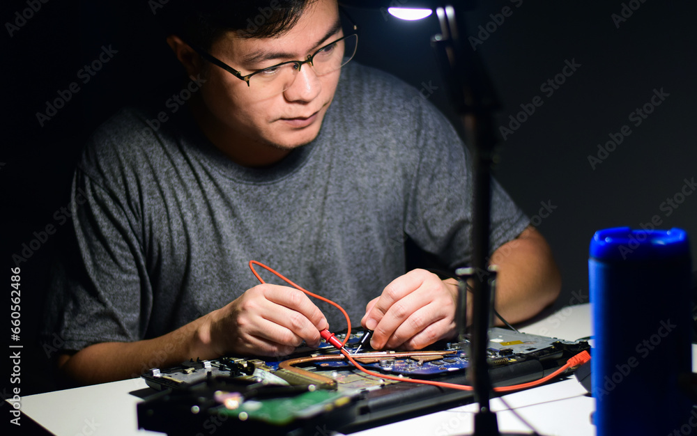 computer technician Motherboard repairman wearing glasses is using an ...