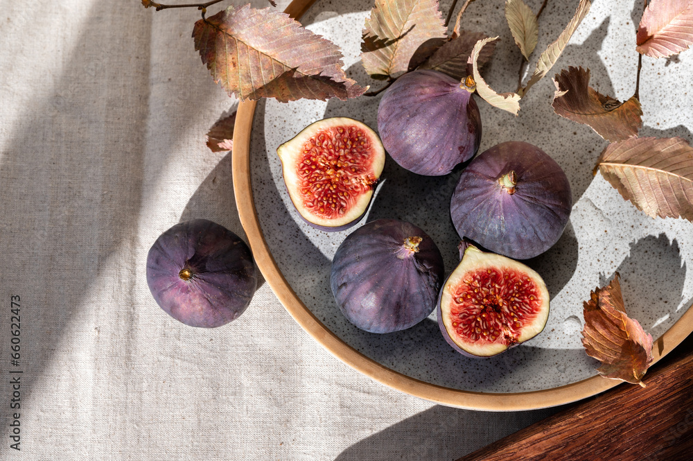 Whole and cut fig fruits on table, on neutral beige linen tablecloth ...