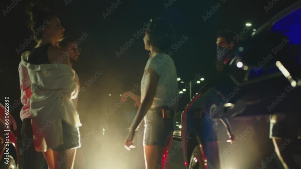 Group of young people dancing near muscle car . Crowd of stylish fans ...