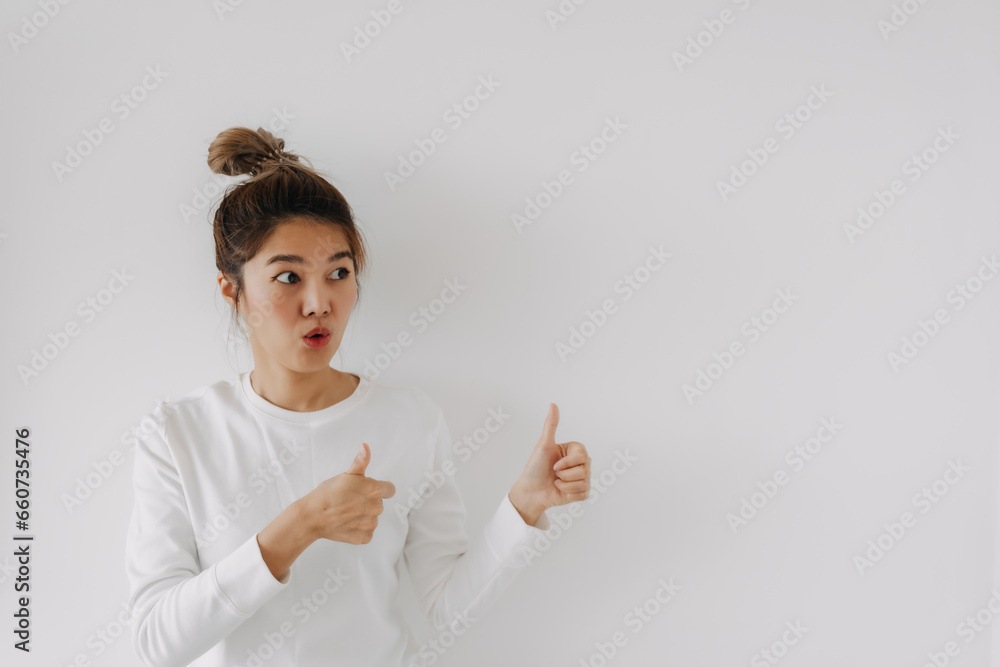 Asian Thai woman bun hair wow face, presenting two hands thumbs up ...