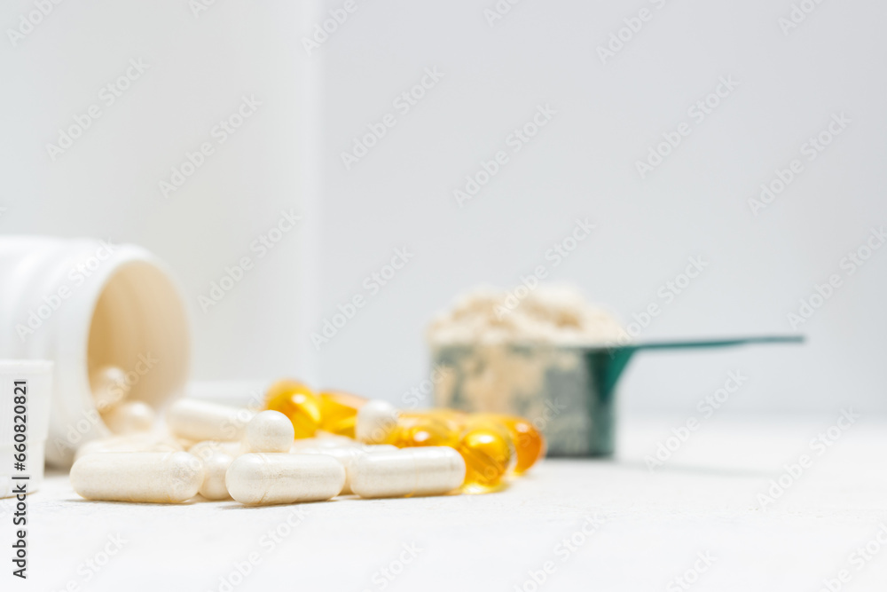 White capsules of amino acids, vitamins and yellow capsules omega 3 and ...