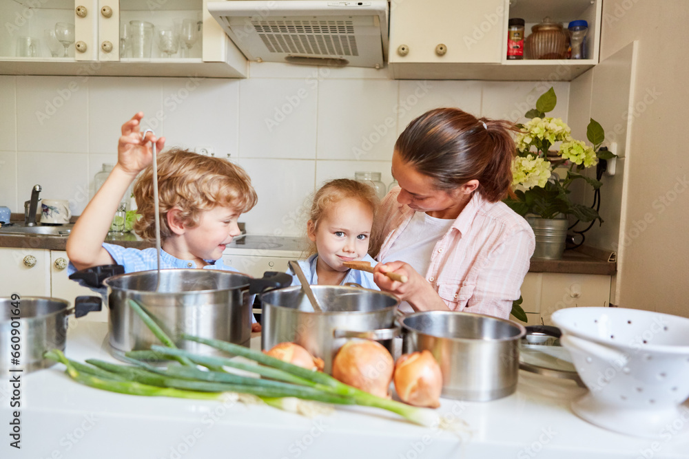 Mother enjoying with kids while preparing soup Stock Photo | Adobe Stock