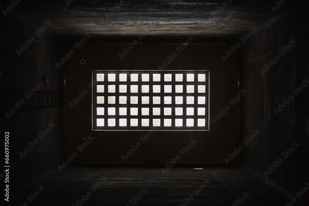 Light behind barred window in the dark prison cell - empty jail ...