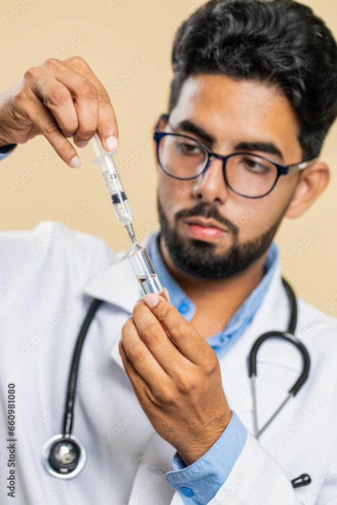 Indian doctor cardiologist man holds syringe needle and ampoule tube ...