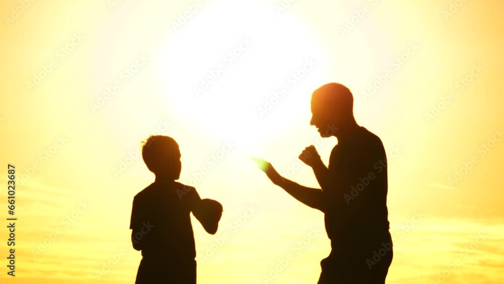 Coach is teaching a kid to box. A kid boxer trains his punches. Father ...