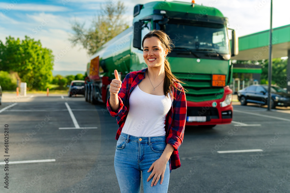 Junior female truck driver standing in front of her truck after she ...