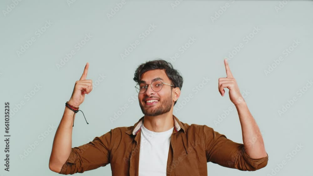 Indian bearded man showing thumbs up and pointing overhead, above head ...