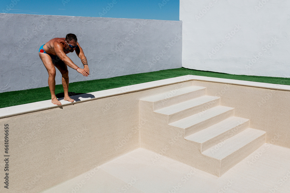 Strong man jumping into empty and dry swimming pool in daylight Stock ...
