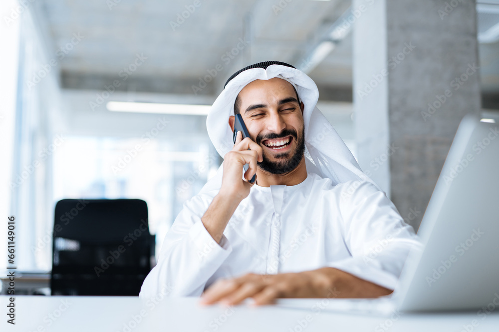 handsome man with dish dasha working in his business office of Dubai ...