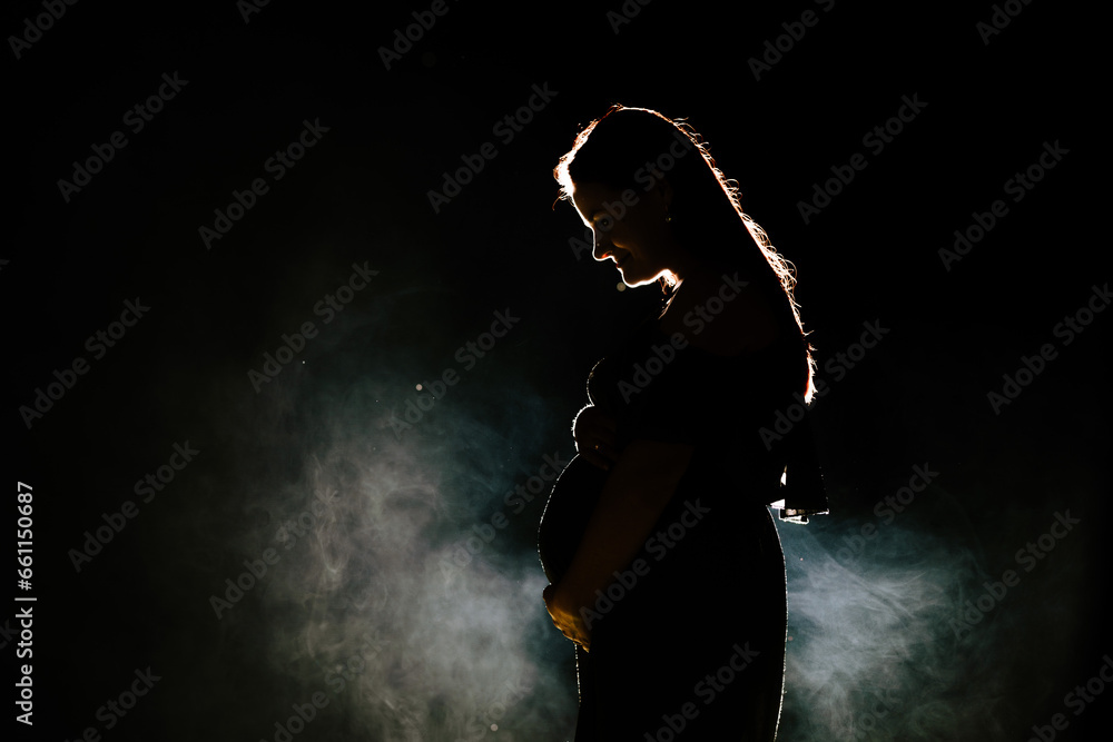 In the low key rim light portrait, the silhouette of a beautiful ...