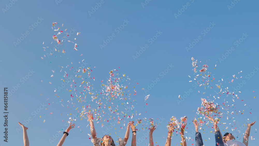 Tossing colorful paper confetti from the hands of young people. Stock ...