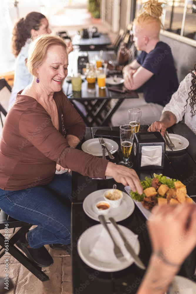 Mulher senior comendo petiscos com amigos em um bar ao ar livre. Stock ...
