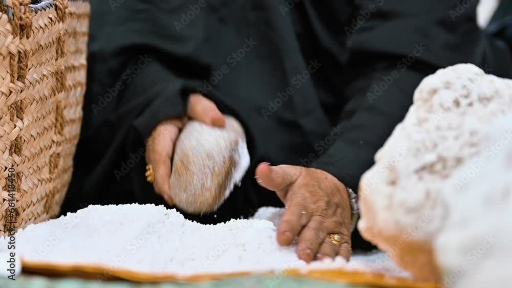 An Arab woman Pulverizing the sea salt by hand, traditionally using a ...