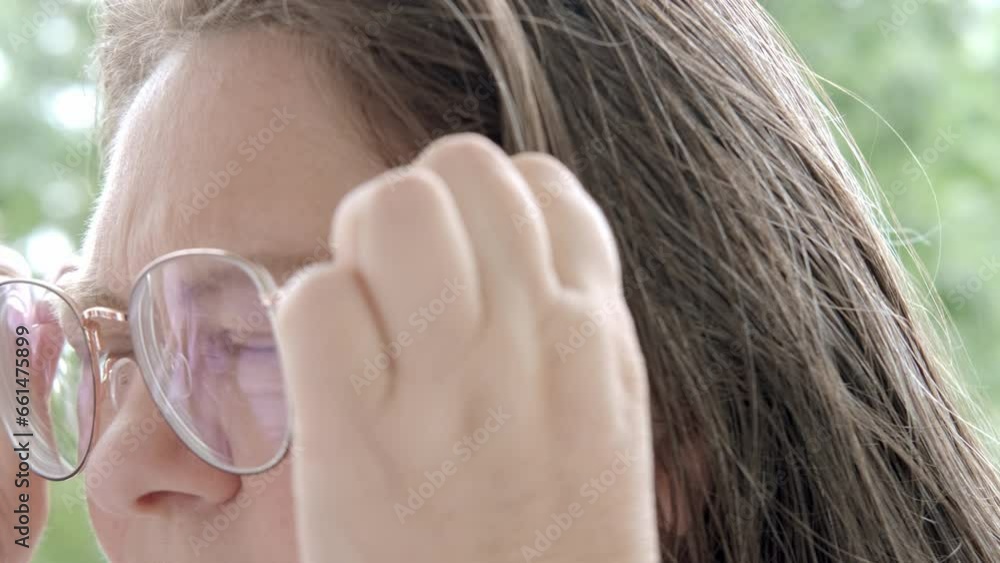 woman 50-55 years old looks into distance, sees poorly, squints, puts ...