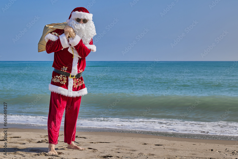 Santa Claus at sea on a hot summer day. Santa Claus stands barefoot on ...