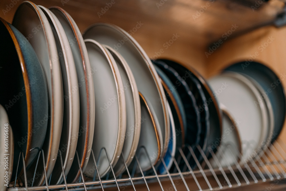 The plates are on the dryer in the kitchen cupboard. The dishes are ...